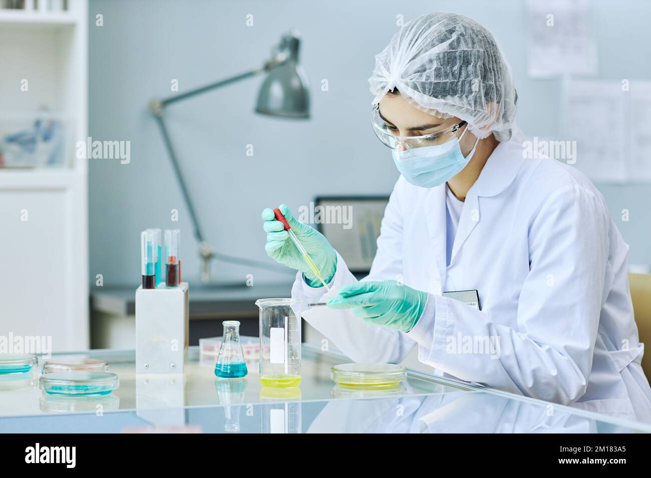 Side view portrait of young woman working in medical laboratory doing ...