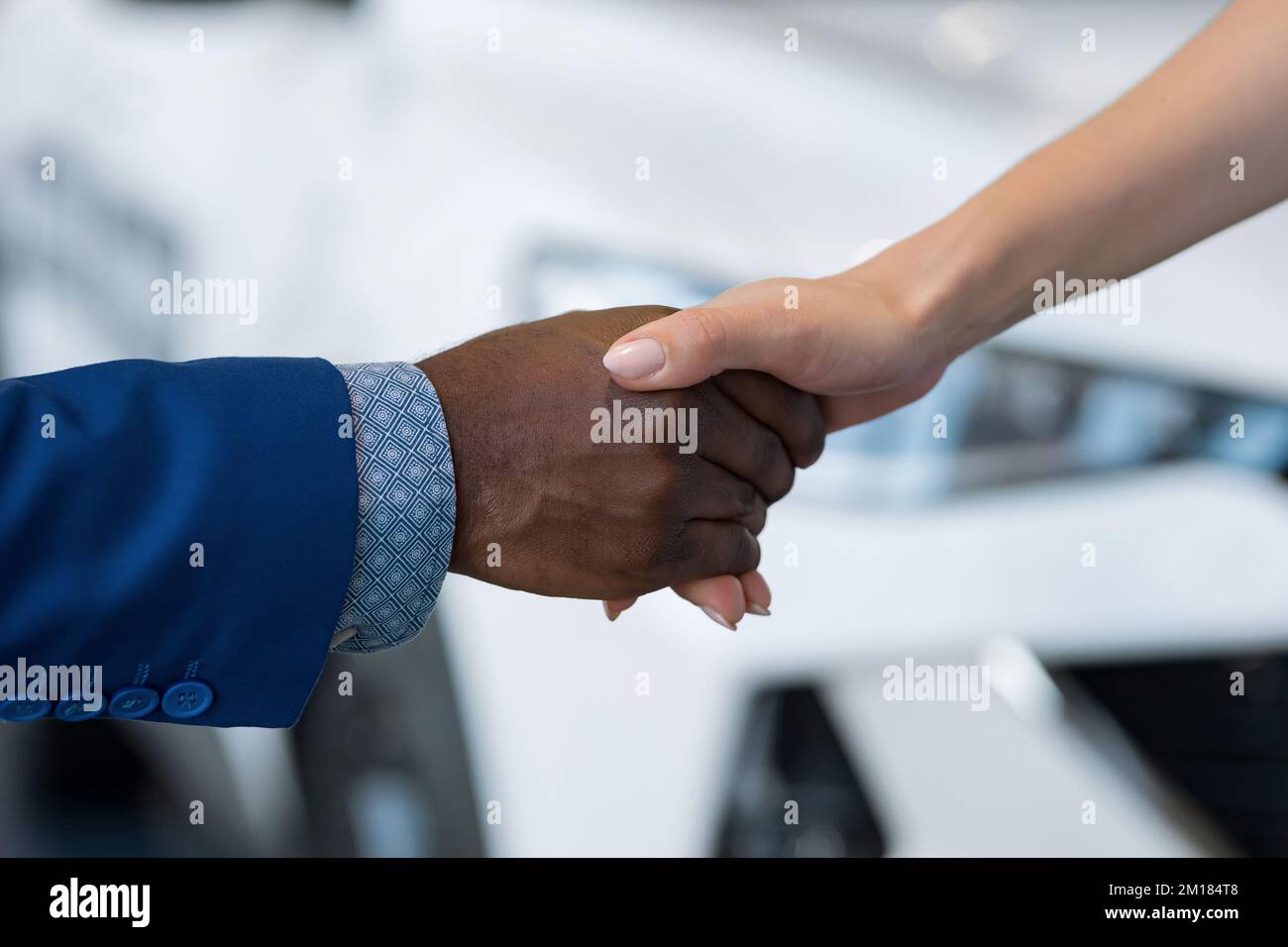 Salesman and female customer shake hands and pass car key Stock Photo ...