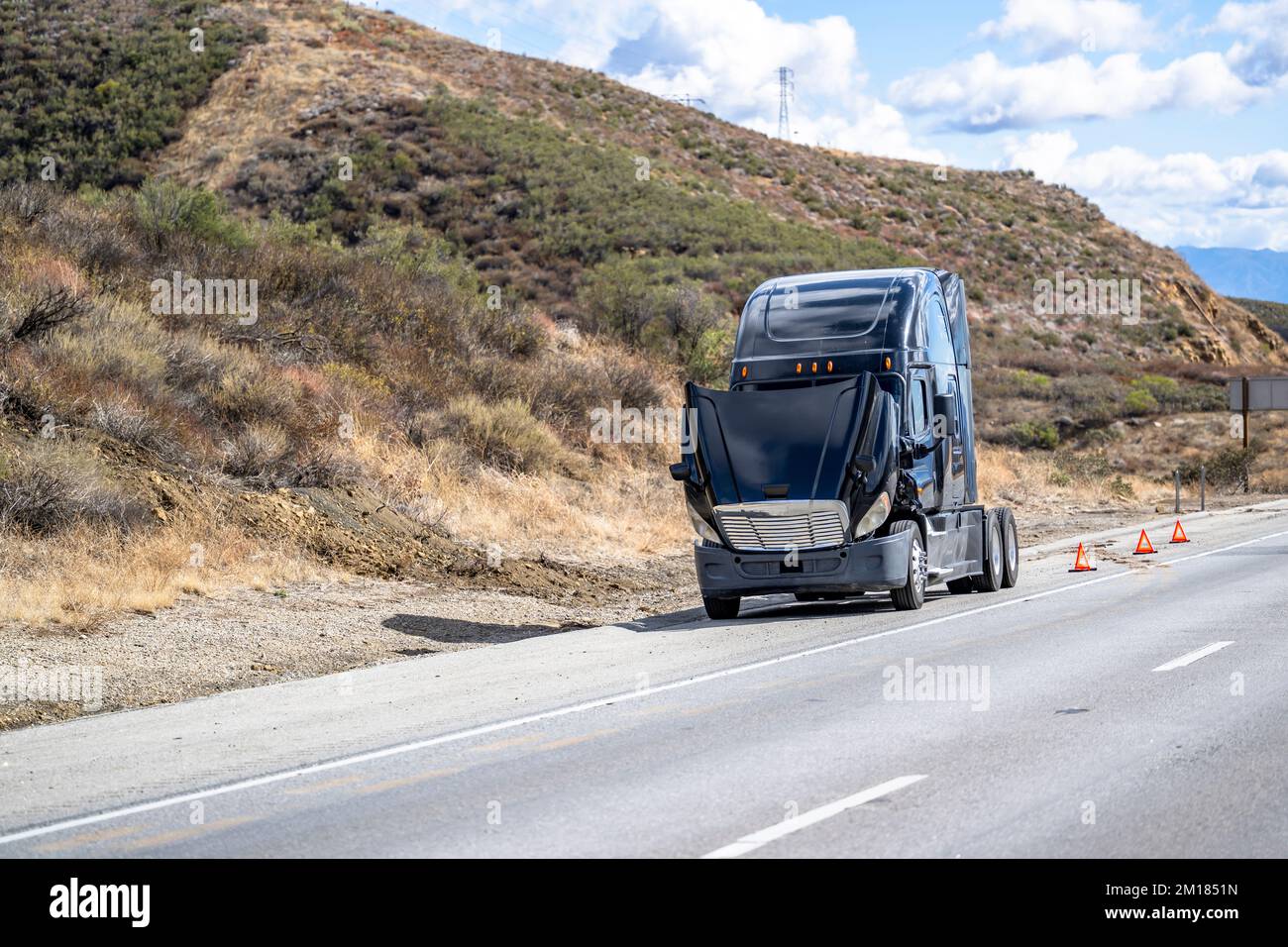 Broken big rig semi truck tractor with open hood and accident warning ...