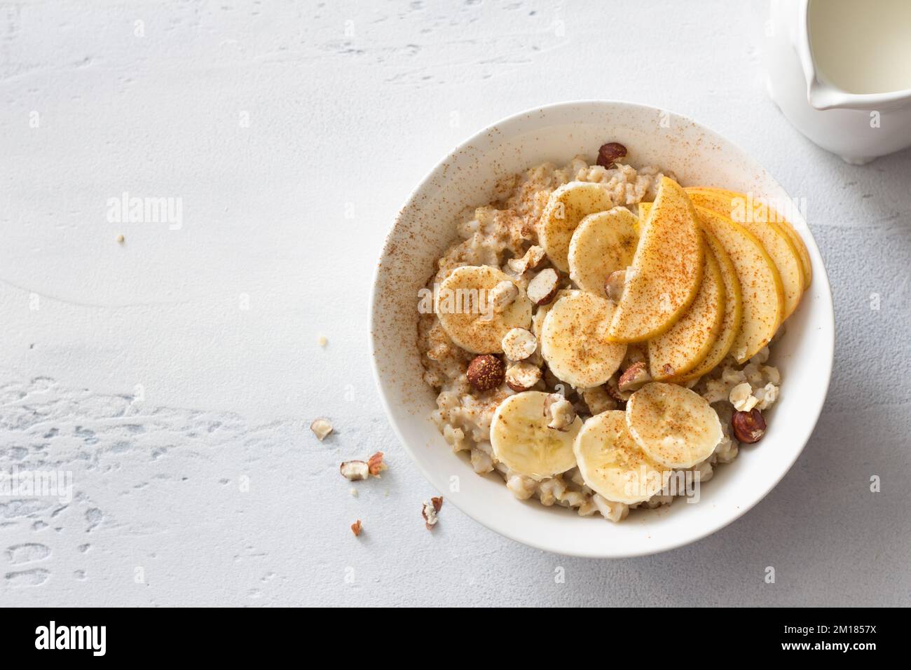 Delicious healthy breakfast. Oatmeal with banana, apple, nuts and ...