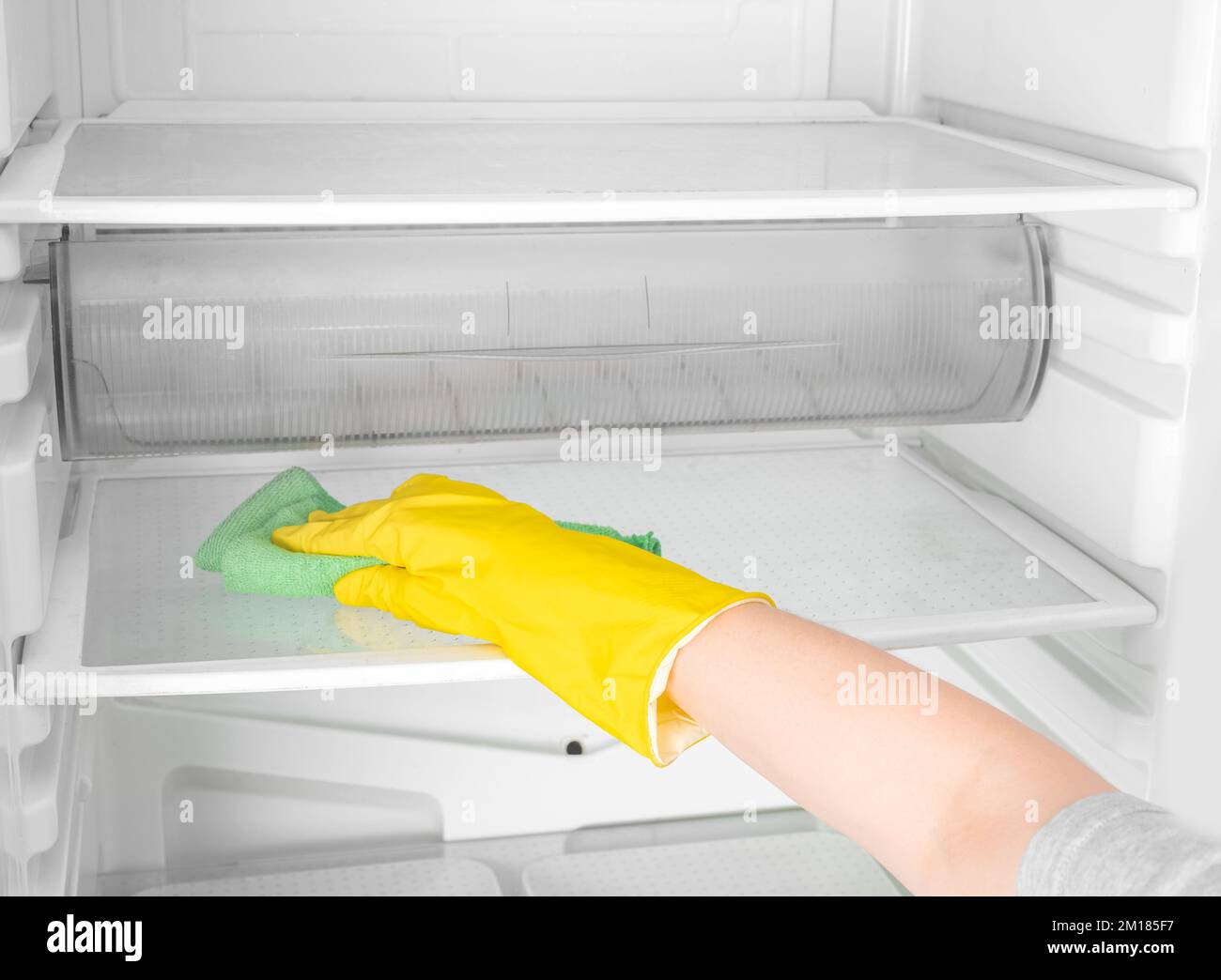 Hand cleaning refrigerator. Person washing refrigerator with rag ...