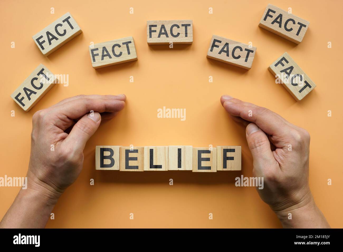 Hands protect the inscription belief from the blocks with the ...