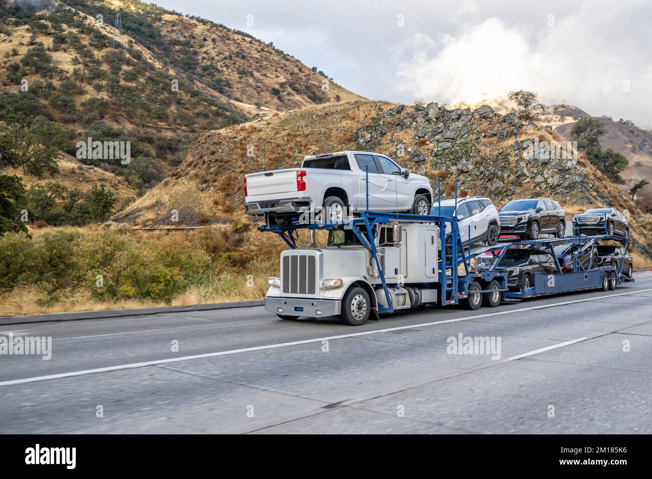 Industrial big rig white car hauler semi truck transporting cars on ...