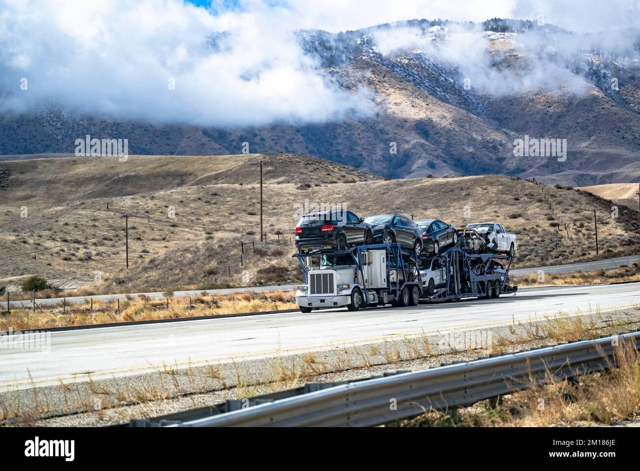 Industrial big rig white car hauler semi truck transporting cars on ...