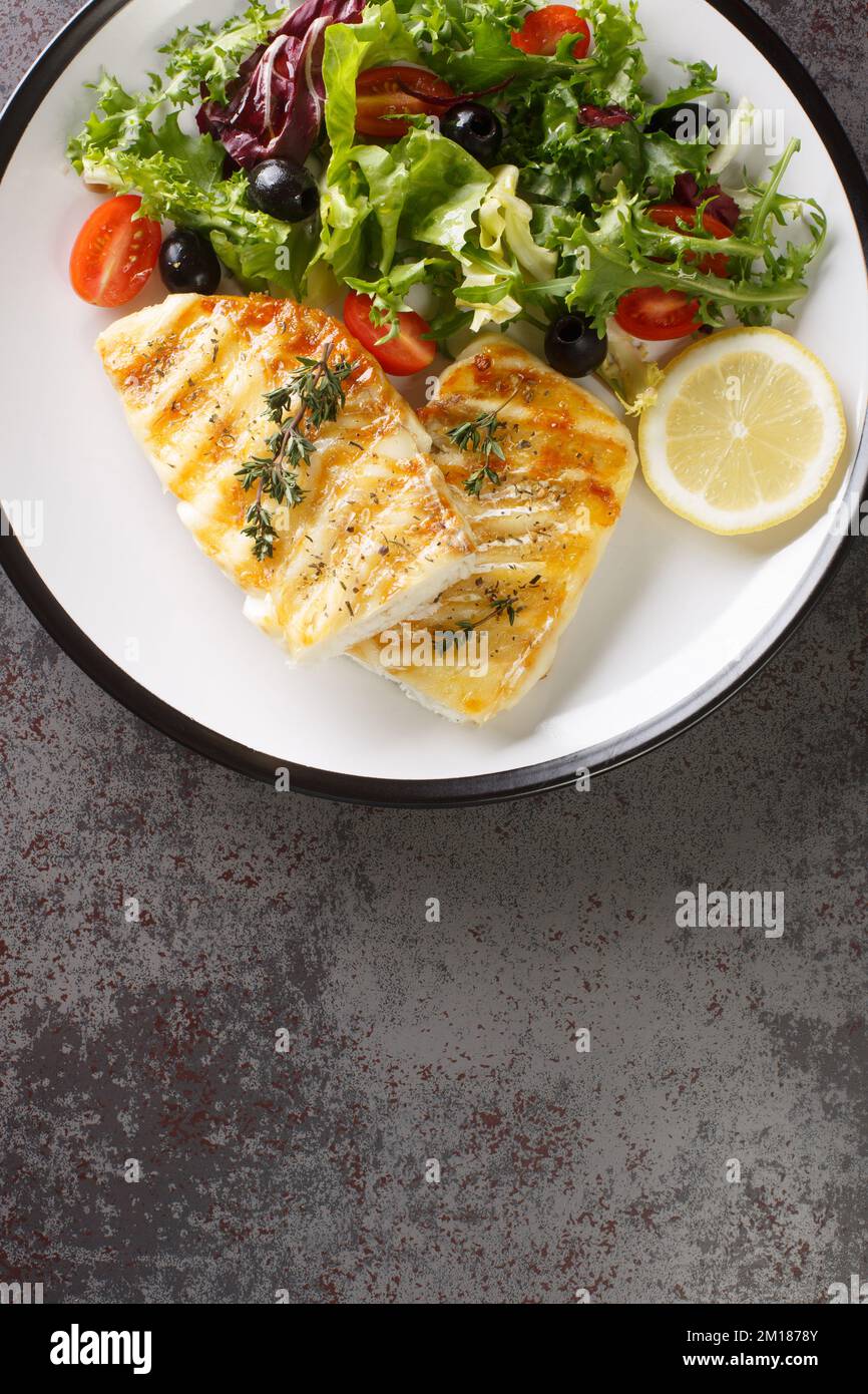 Healthy food serving grilled fish cod with fresh vegetable salad and ...