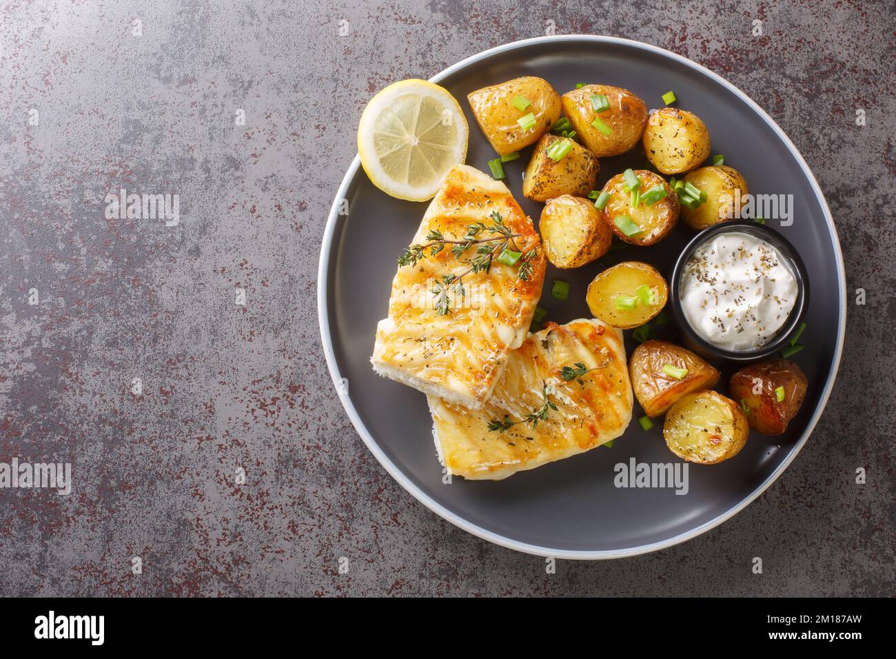 Grilled fish cod fillet with thyme served with baked potatoes, cream ...