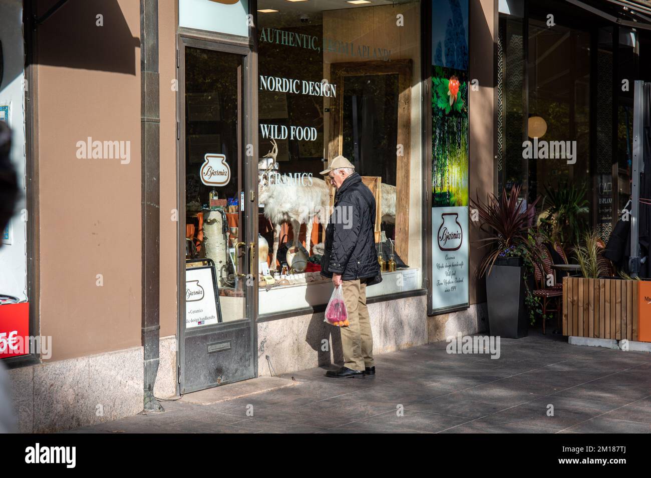 Elderly man looking at souvenir store window display on ...