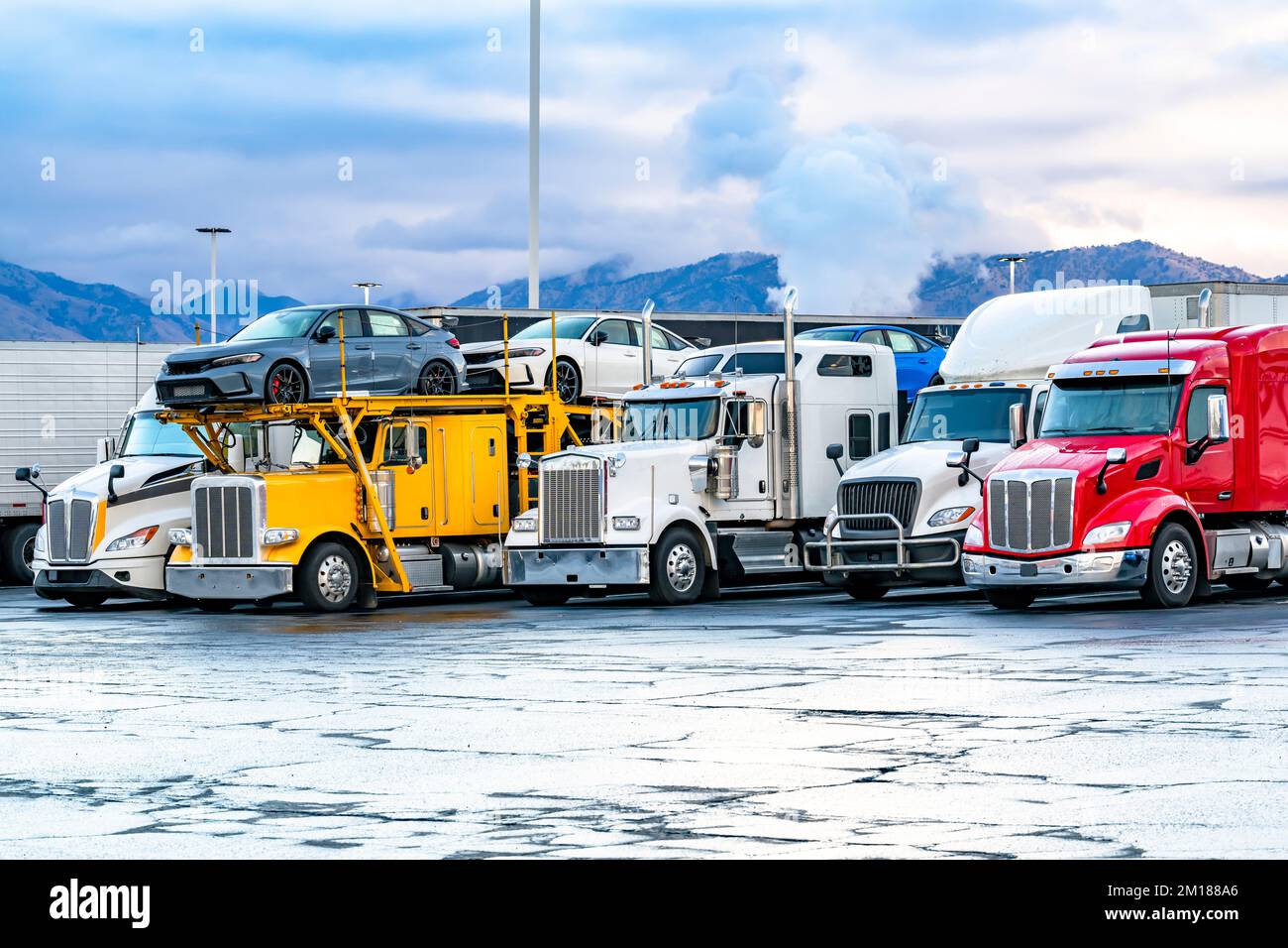 Row of professional big rigs semi trucks with semi trailers standing on ...