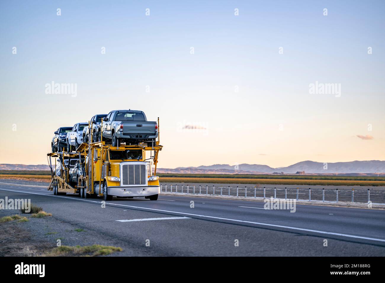 Industrial big rig yellow car hauler semi truck with chrome parts ...