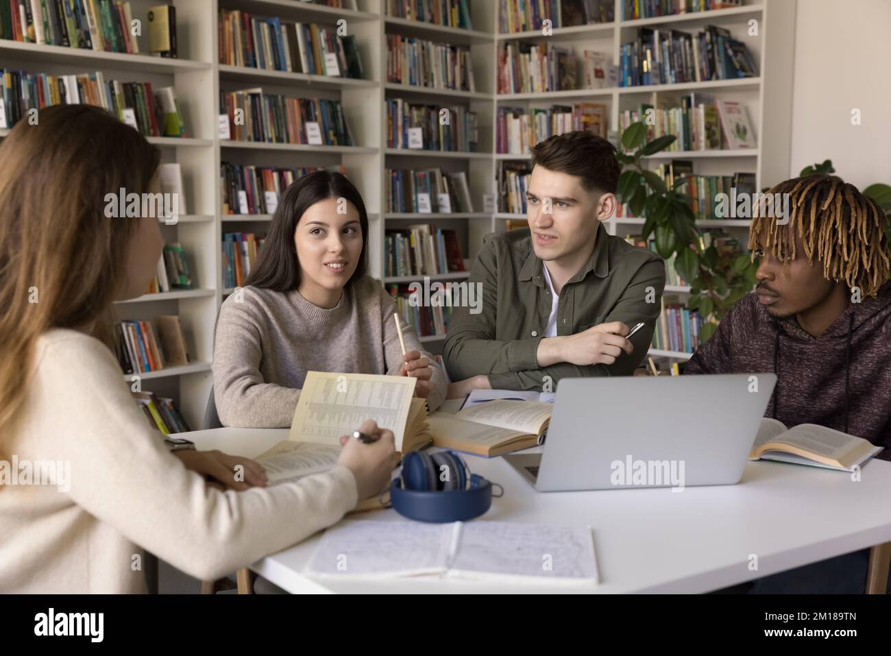 Group of young multiethnic college students talking in library Stock ...