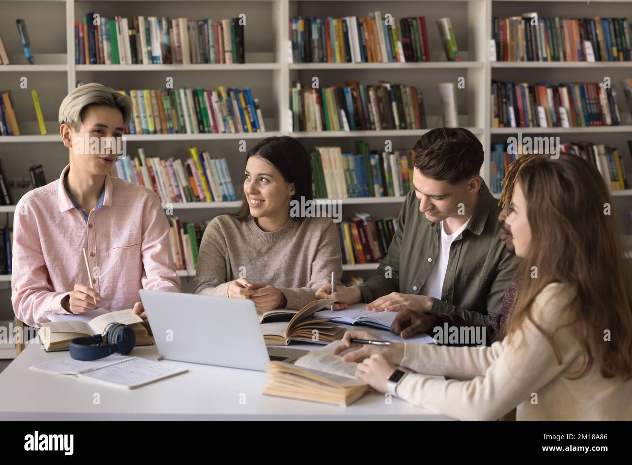 Happy Asian students group leader speaking at meeting in library Stock ...