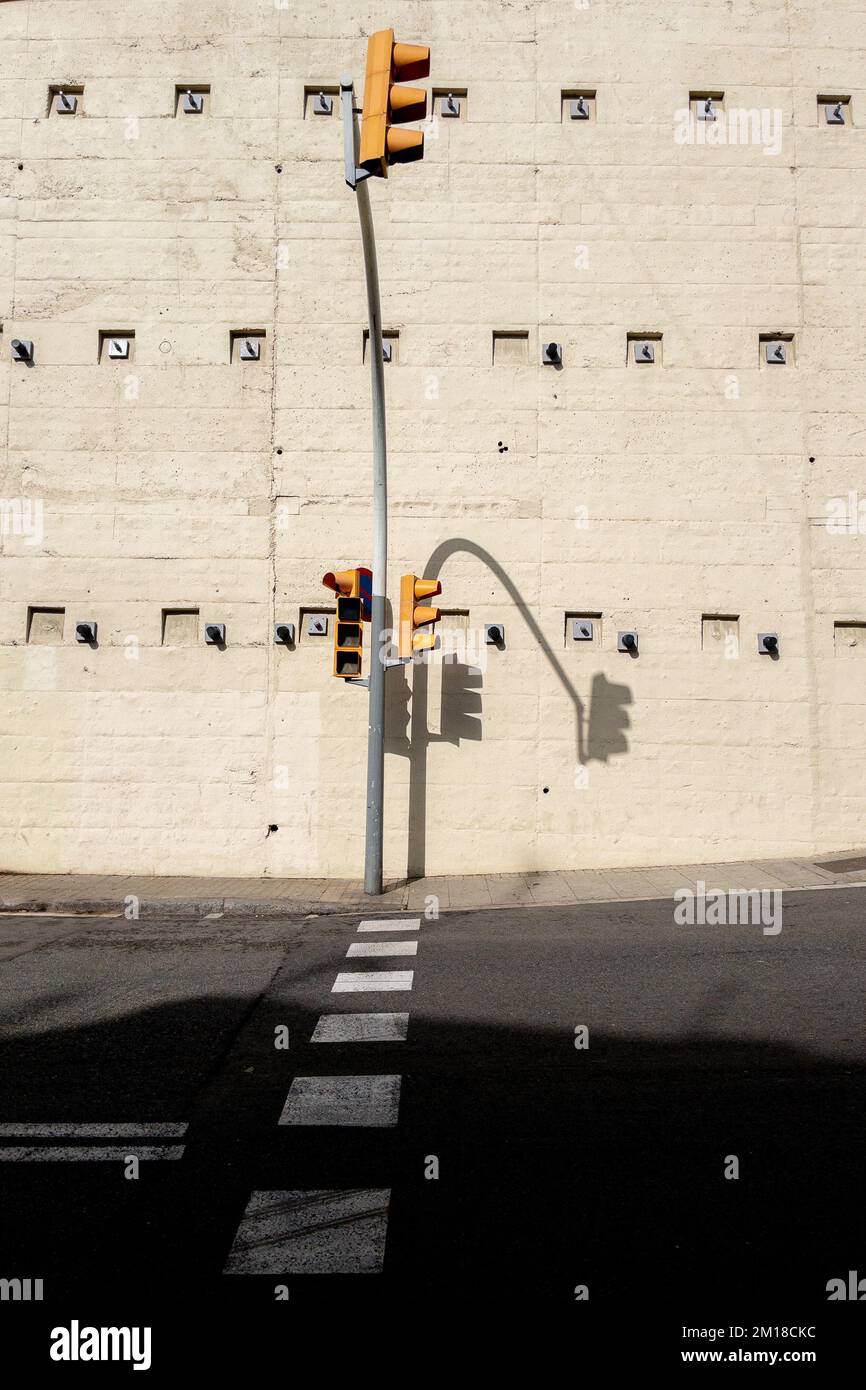 A vertical shot of a pole with traffic light on the street against a ...