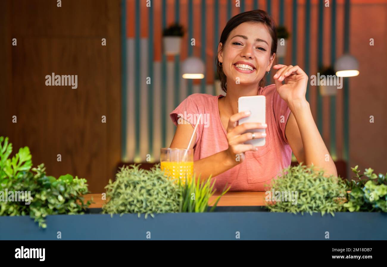 Portrait of happy woman smiling and using mobile phone. People ...