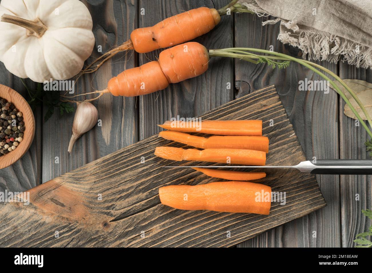 Cut ripe raw orange carrot into slices on kitchen wooden board. Sliced ...