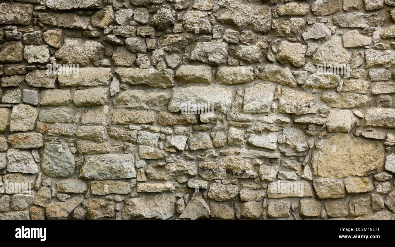 Texture of a stone wall with many big brown and grey stones armed with ...