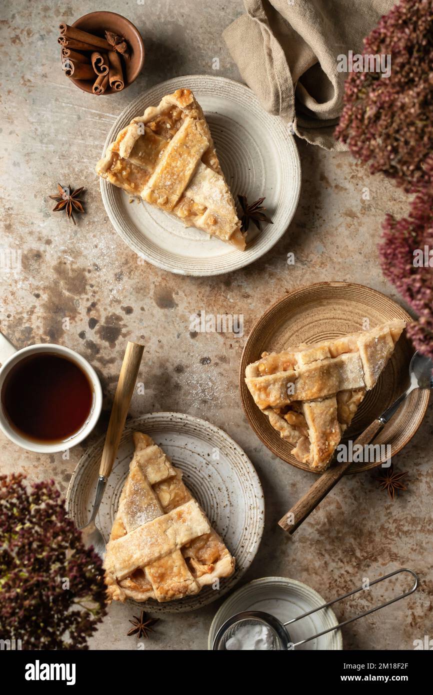 Apple pie serving in plates for tea time, table scene on brown textured ...