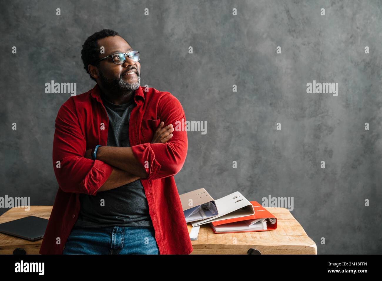 Black bearded man in eyeglasses smiling while working in office Stock ...