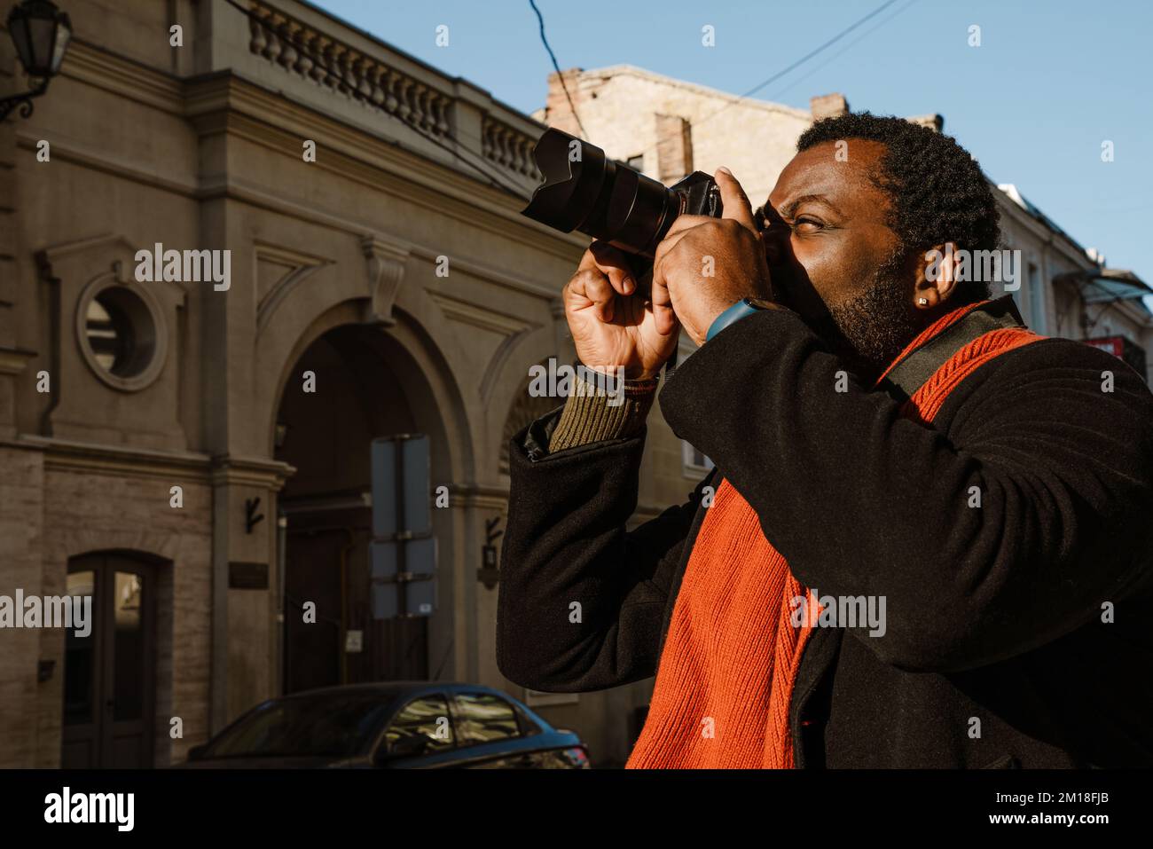Black mid man taking photo while walking at city street outdoors Stock ...