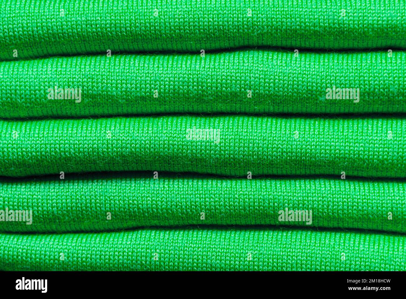 BACKGROUND TEXTURE - Folded pieces of green knitted fabric Stock Photo ...