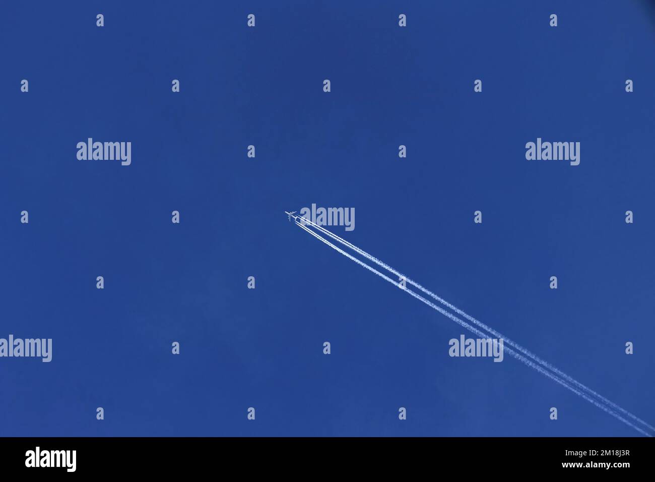 Airplane contrails in Blue Sky for use as a background Stock Photo - Alamy