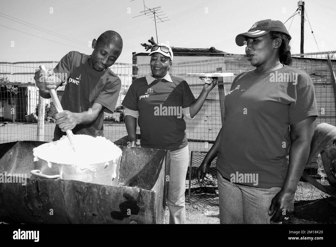 A grayscale shot of people cooking maize porridge in the street Stock ...