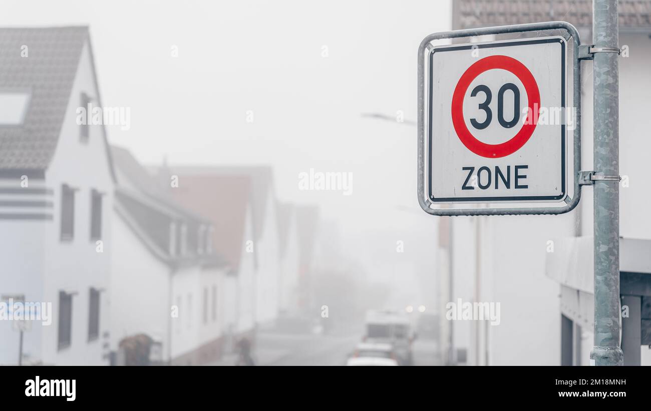 A zone 30 sign with a street on a foggy day in a background Stock Photo ...