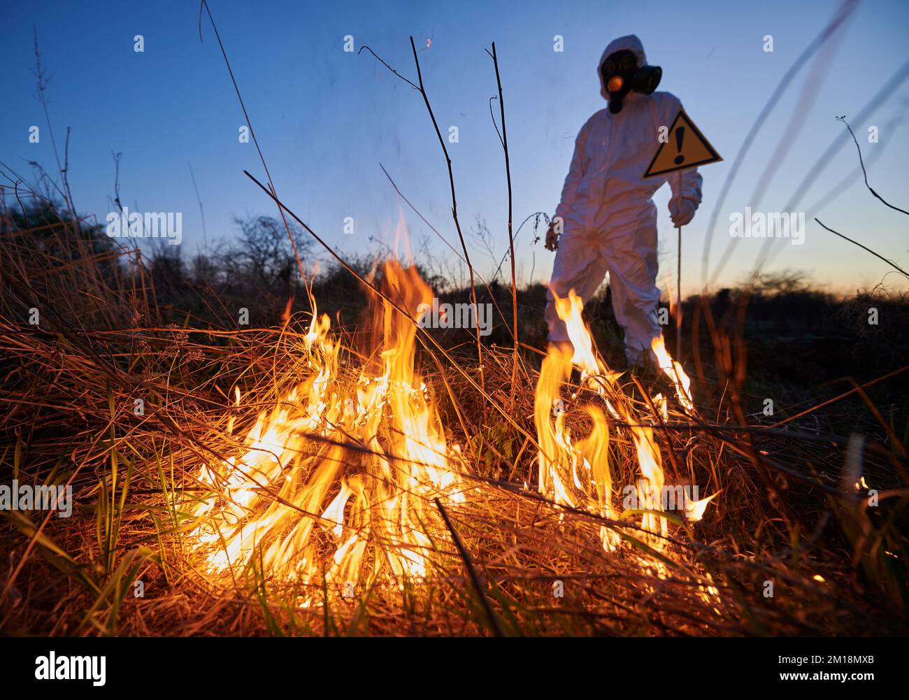 Fireman ecologist working in field with wildfire at night. Man in ...