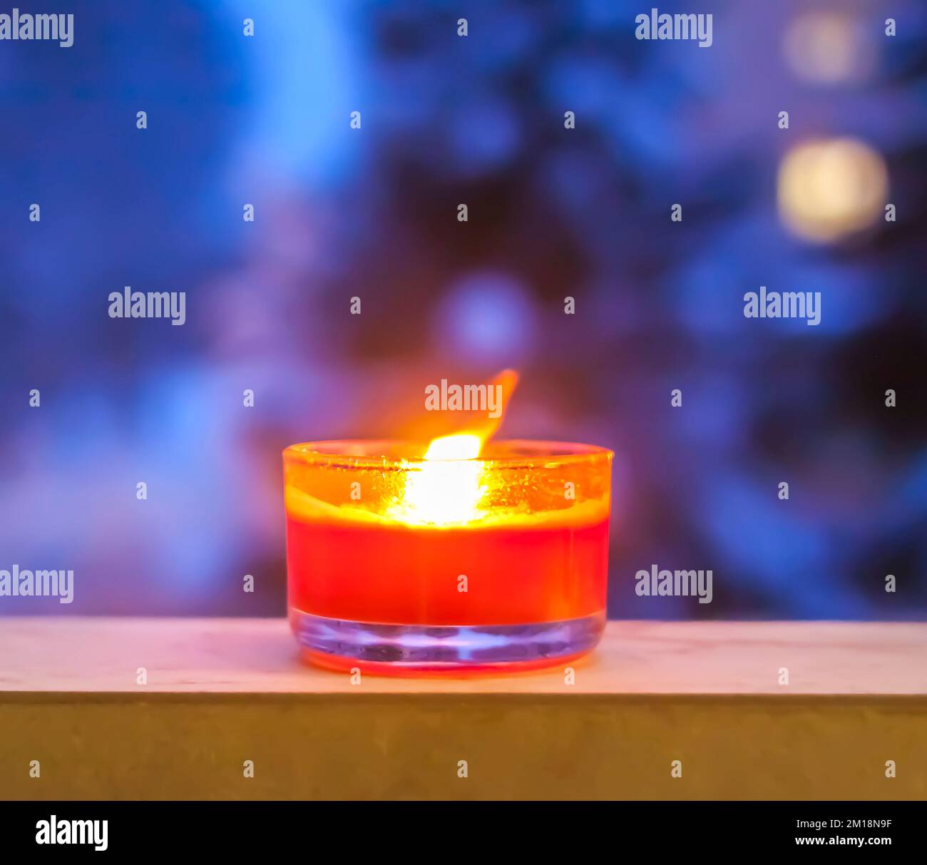 Burning red candle on winter background Stock Photo - Alamy