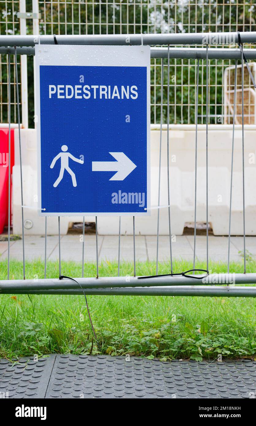 Pedestrian walkway sign at construction building site fence Stock Photo ...