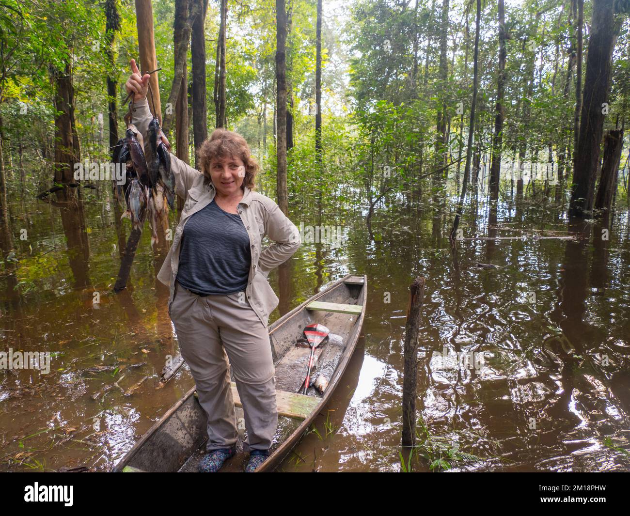 Caucasian woman in the small wooden boat with fishes catch from the ...