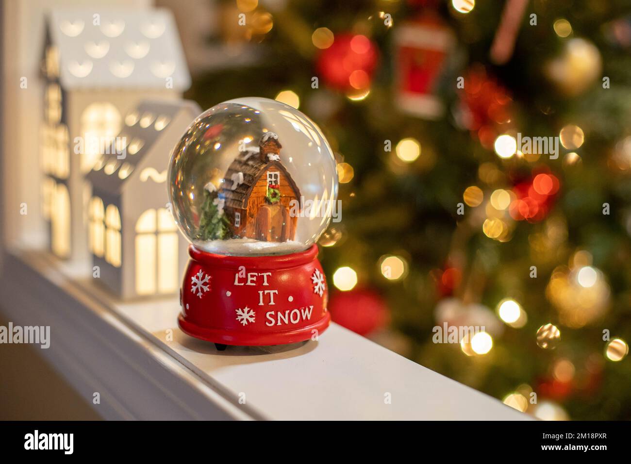 A small Christmas snow globe with a "Let it snow" text on it on the ...