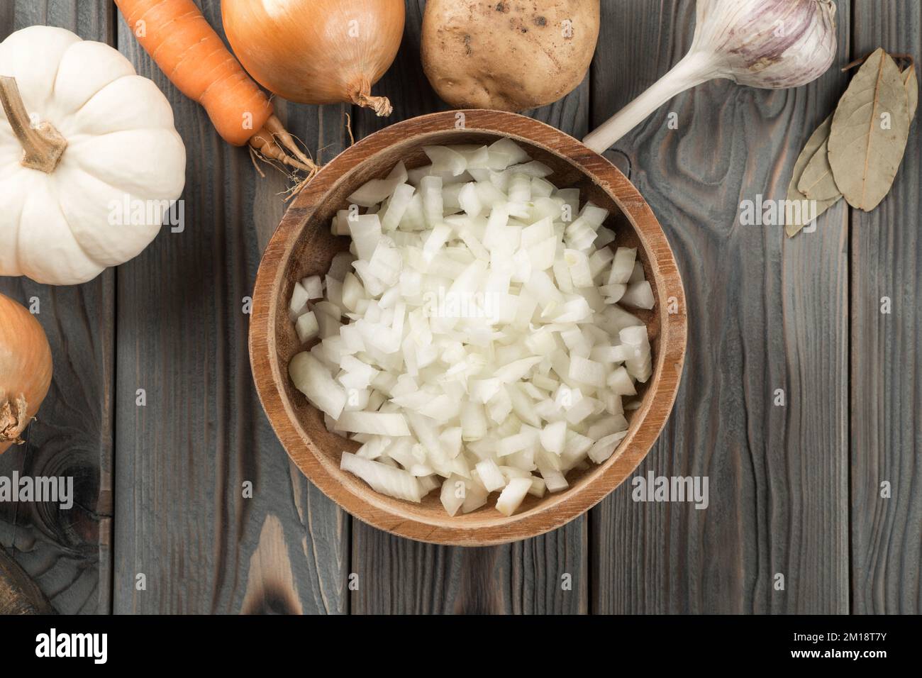 Cut spicy onion into cubes. Bowl full of white diced onion on kitchen ...