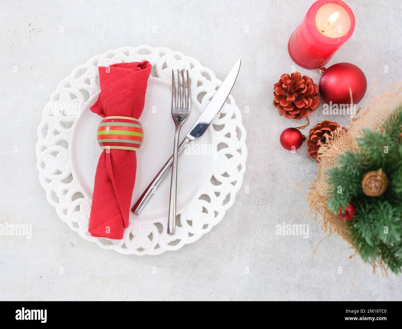 a red handkerchief with a red candle and a Christmas tree on a concrete ...