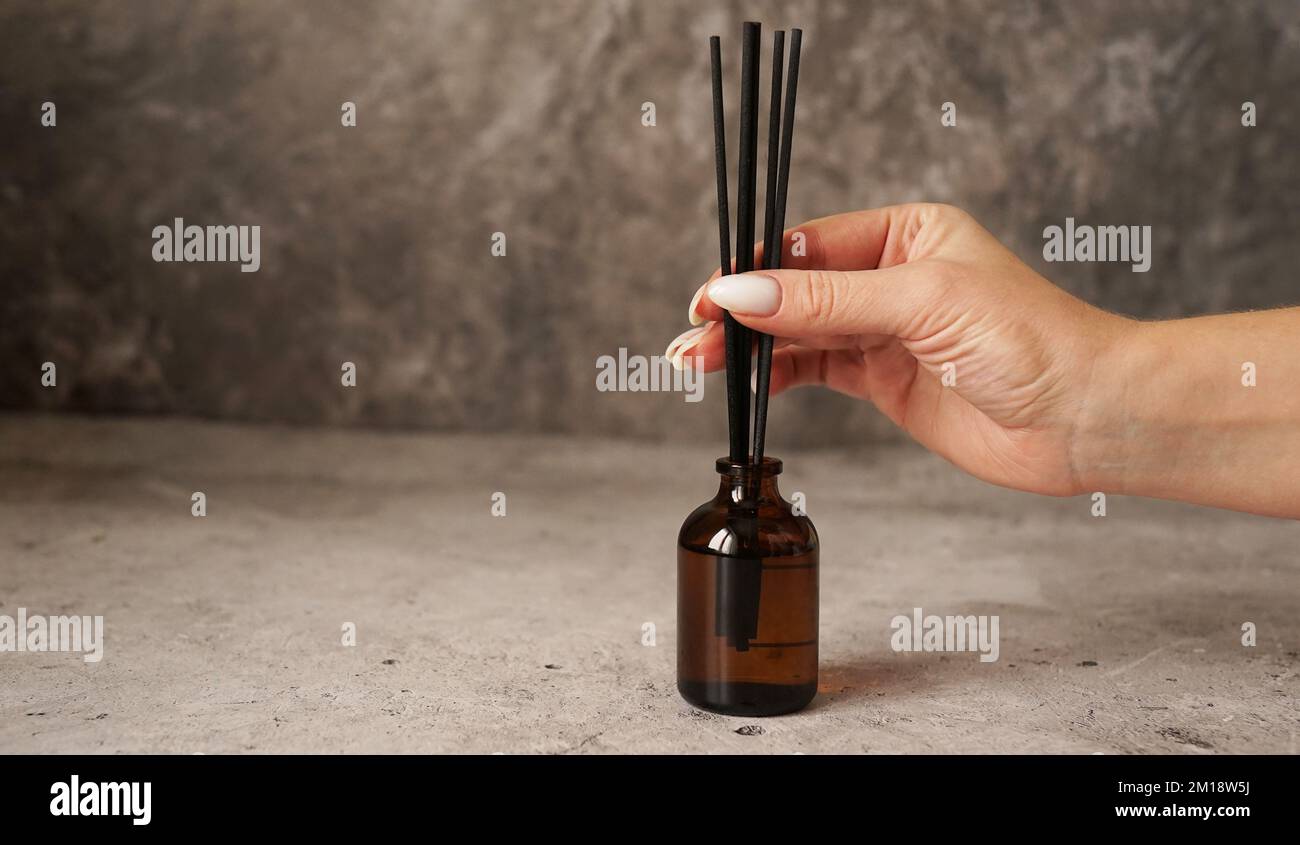 Aromatic reed diffuser bottle with black sticks on a dark marble ...