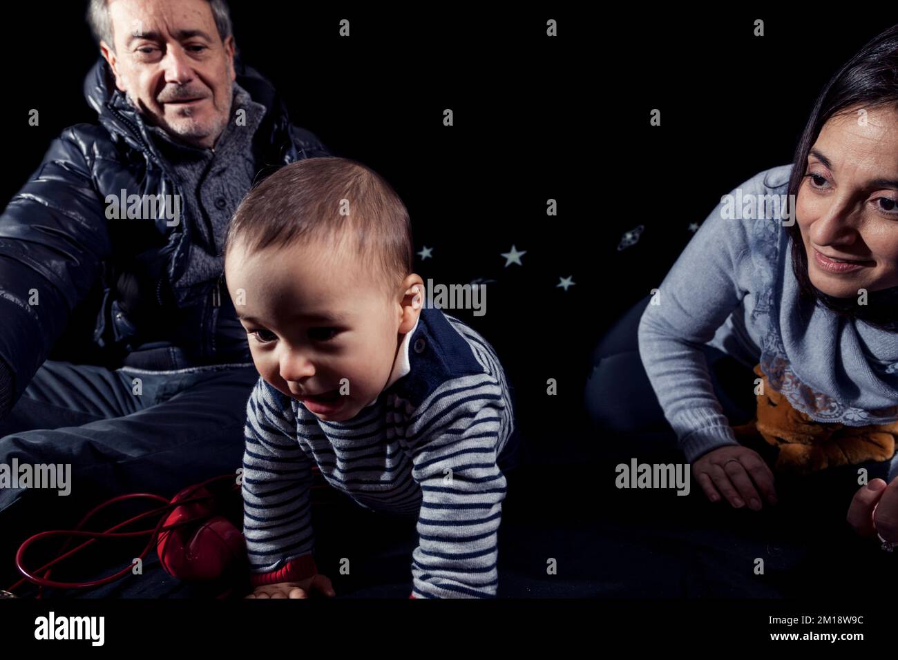 portrait of smiling little boy hugging with his parents sitting on ...