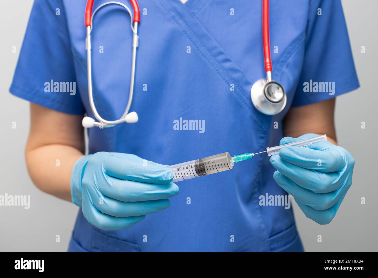the doctor removes the cap from the syringe. doctor holding a syringe ...