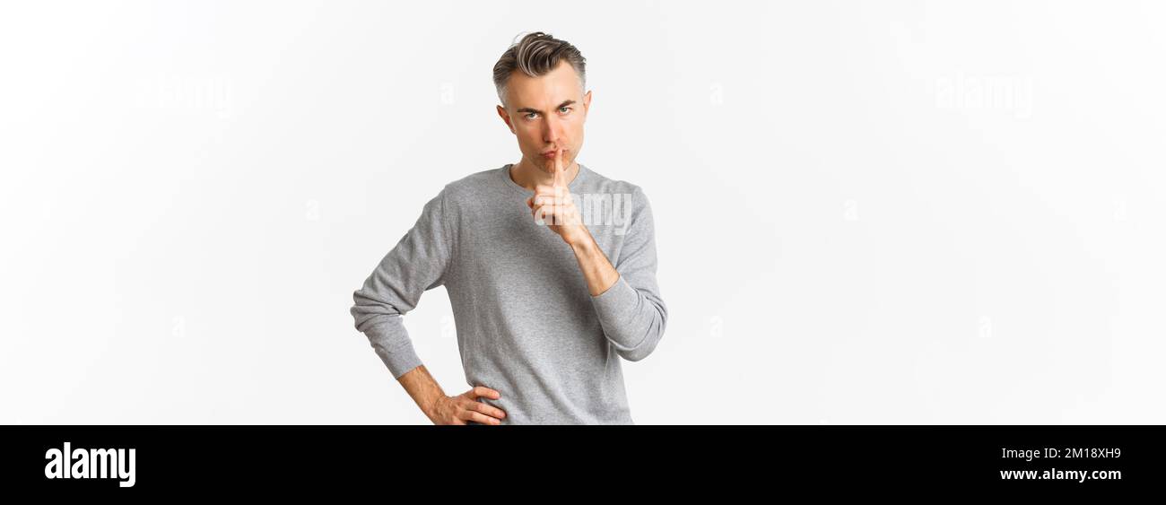 Disappointed middle-aged man with grey hair, hushing at you, scolding ...