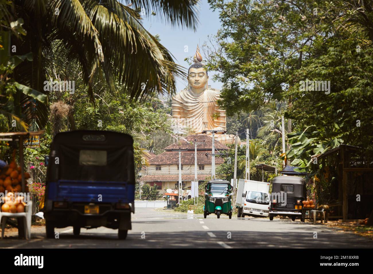 Traffic on rural road against Buddha statue. Wewurukannala Buduraja ...