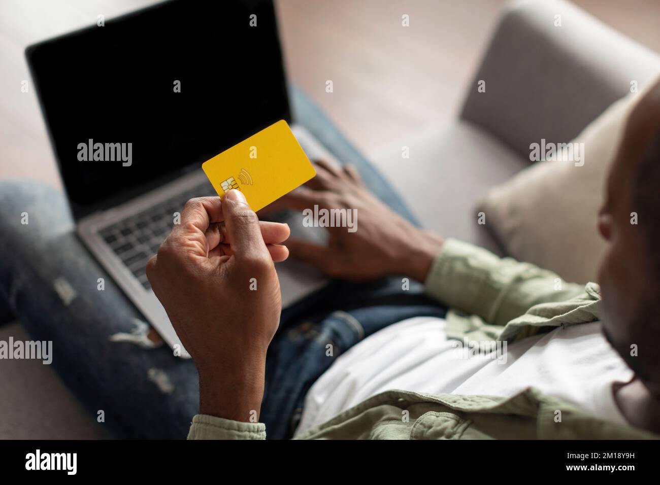 Adult black male typing on computer keyboard with empty screen, using ...