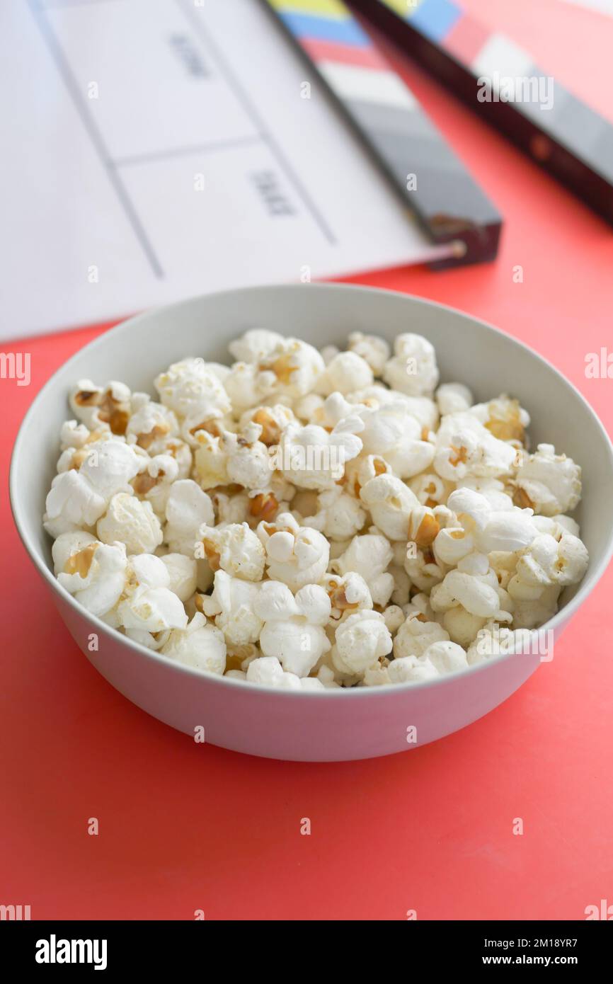 vertical shot of Movie clapper board and popcorn on table top view ...