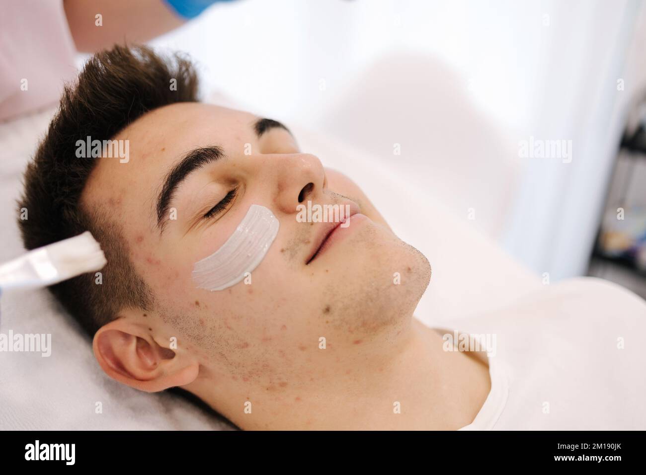 Young man during peeling treatment in beauty clinic. Handsome man in ...
