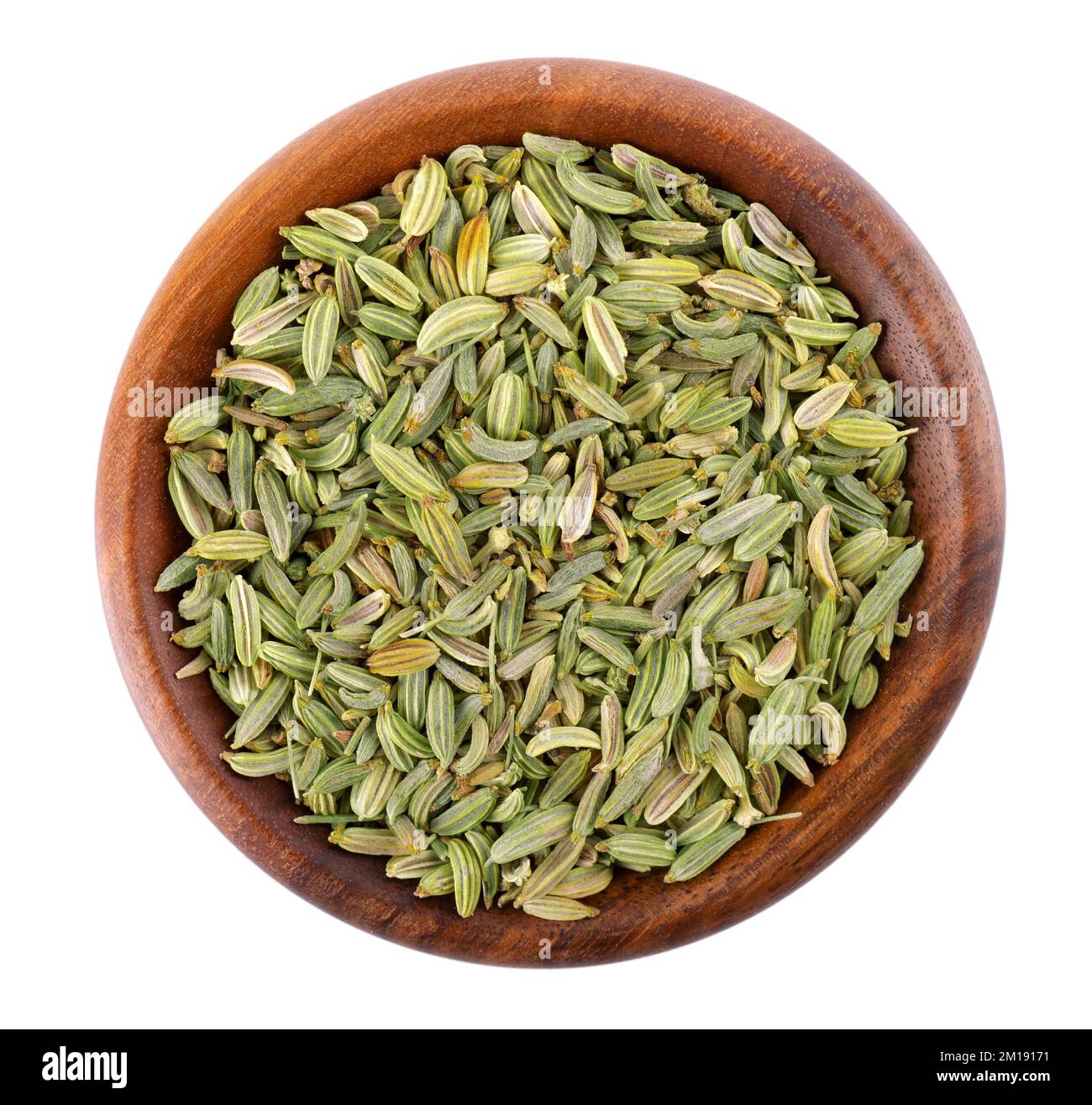 Fennel seeds in wooden bowl, isolated on white background. Green fennel ...
