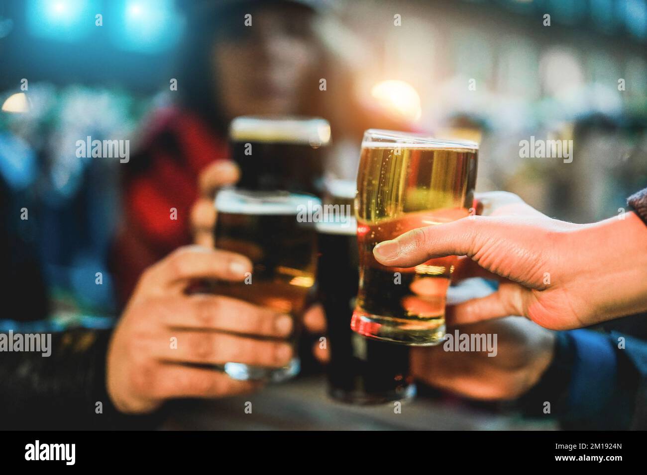 Young group of people having fun cheering with beer outdoor at bar ...