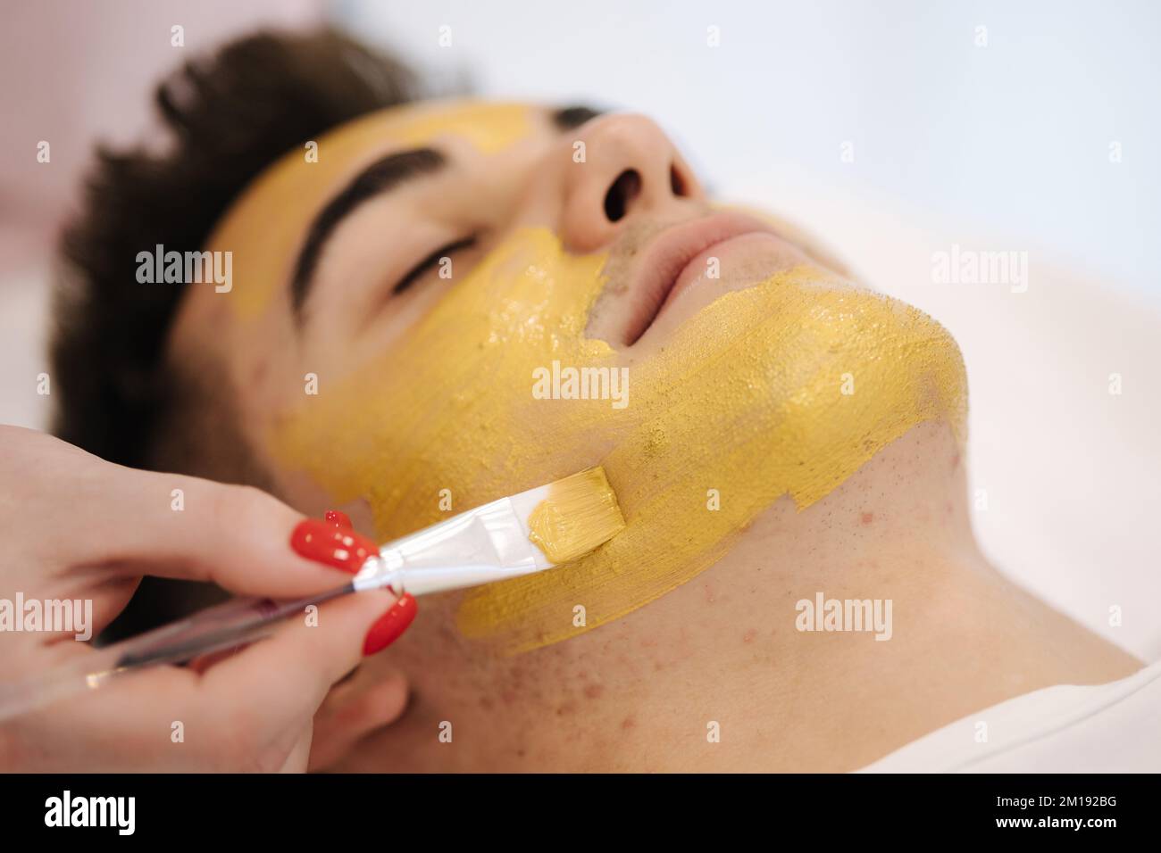 Handsome man having golden mask in beauty studio. Male in spa salon ...