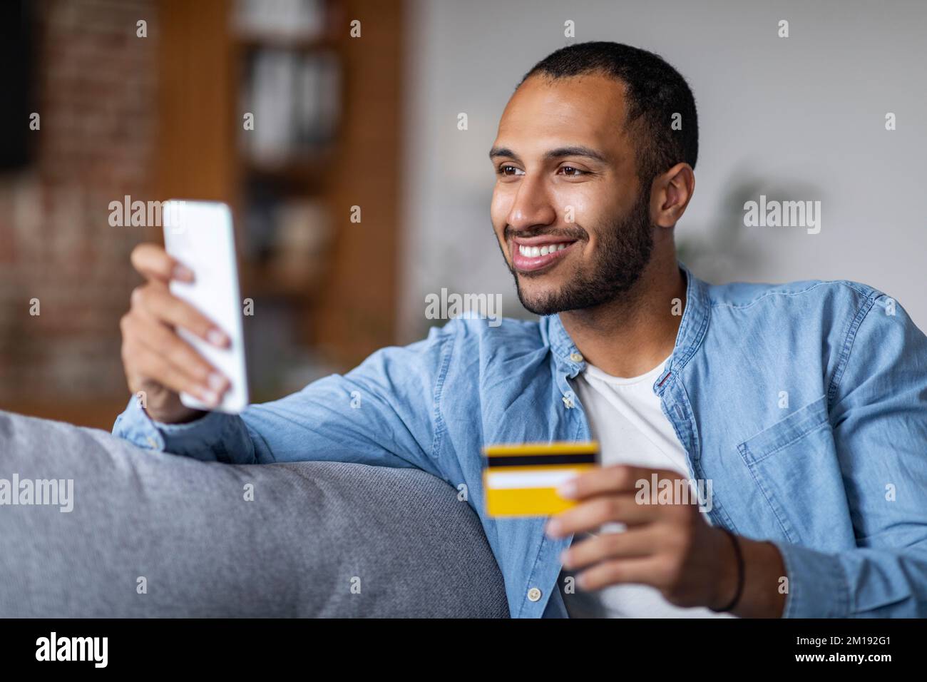 Online Banking. Smiling Black Man Using Smartphone And Holding Credit ...