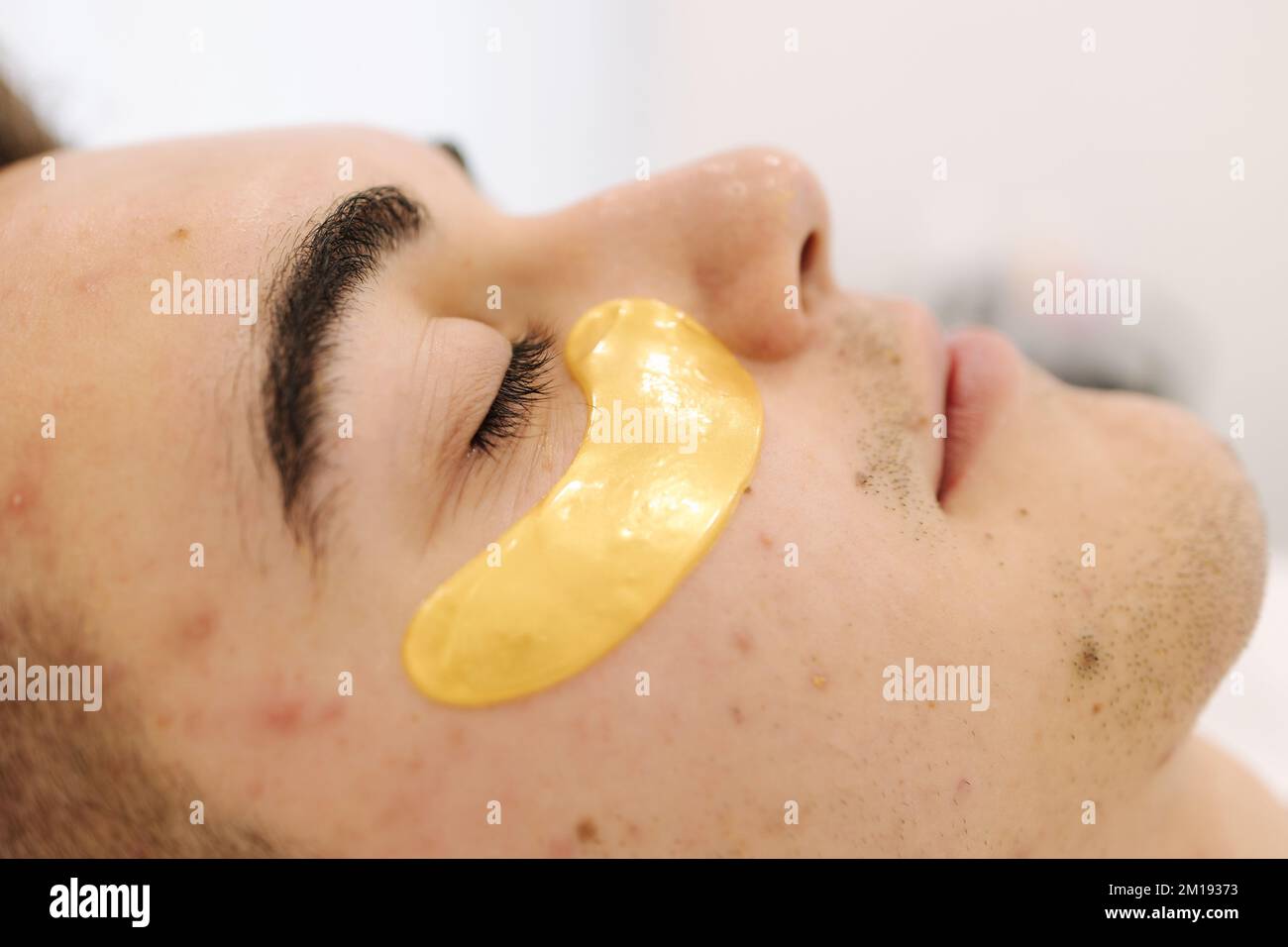 Handsome man with golden patch under eyes. Beauty studio. Spa salon ...