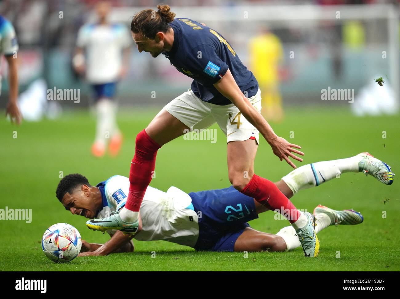England's Jude Bellingham (left) goes down from a tackle from France's ...