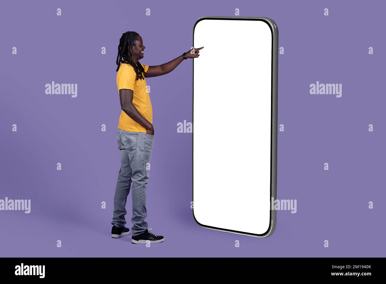 Cute african american guy using huge cell phone, mockup Stock Photo - Alamy
