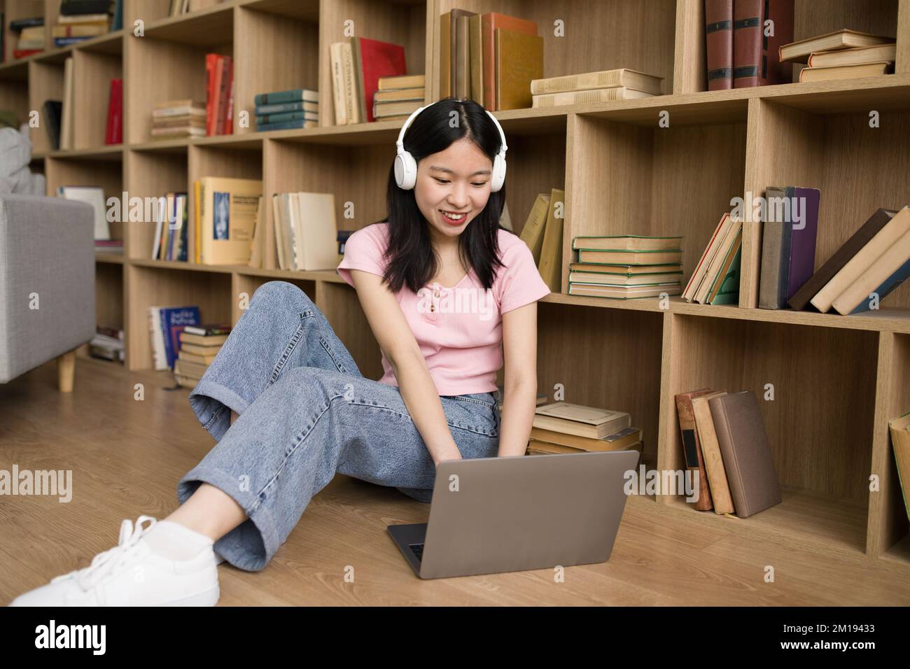 Distance learning. Asian lady in headphones studying with laptop at ...