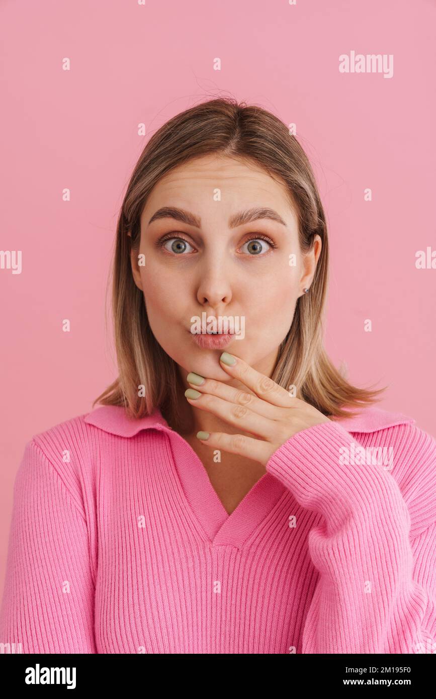 Young surprised girl touching her chin with puckering lips looking in ...